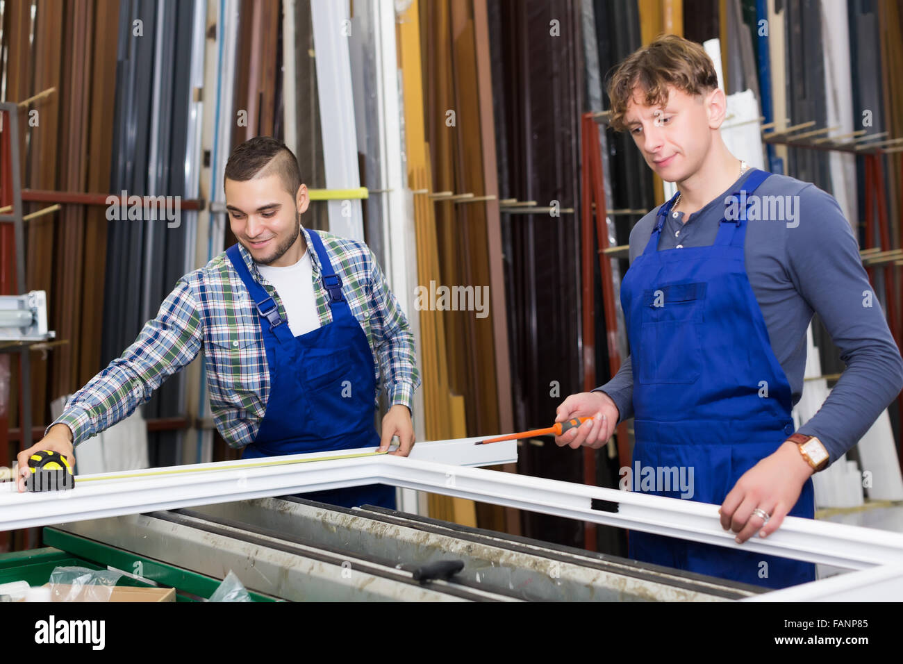 workmen working with window profiles at indusrty plant Stock Photo - Alamy