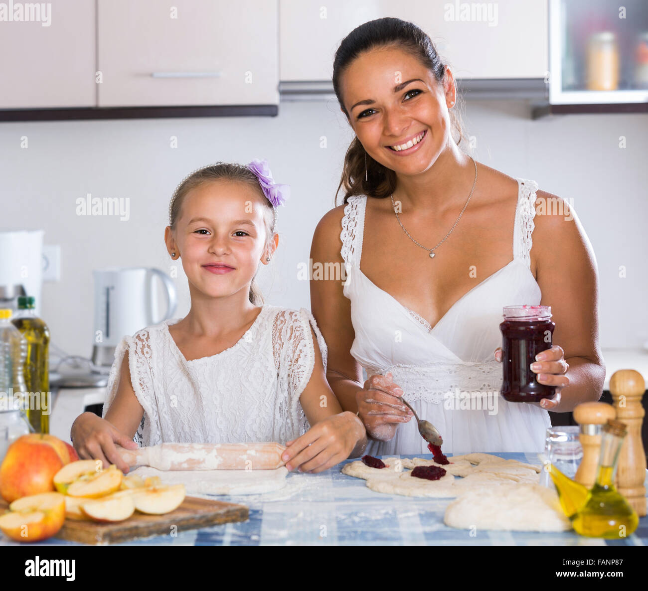 Portrait of young spanish woman and child cooking sweet pies Stock ...