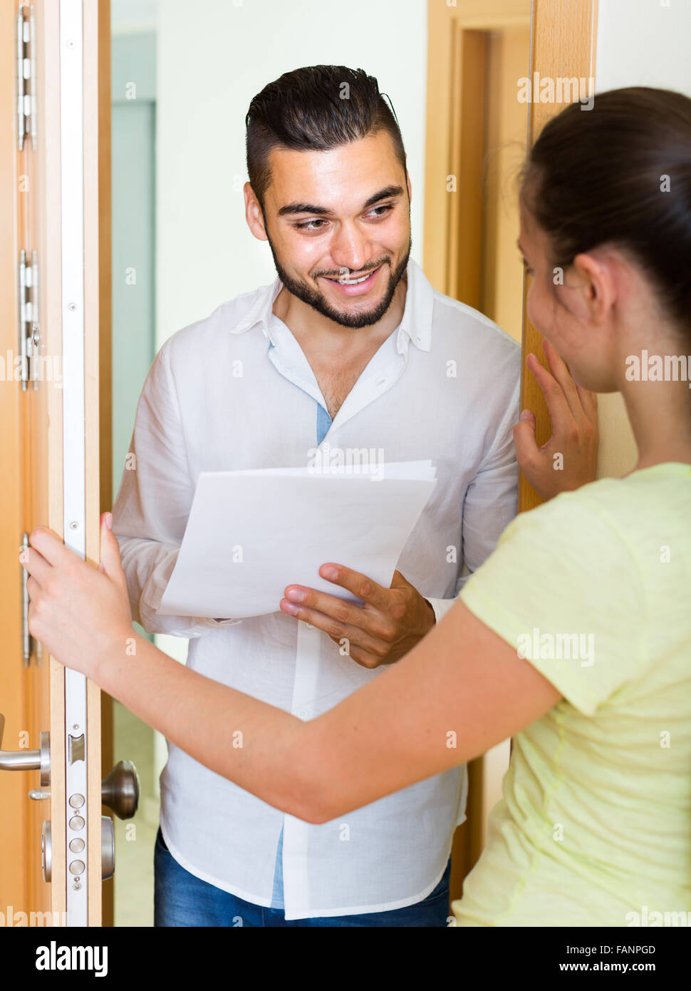 Smiling spanish man and woman standing with papers at the door Stock ...