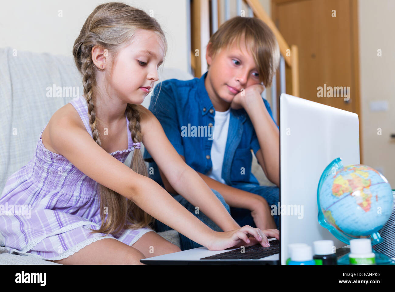 Little brother and sister playing computer game on laptop Stock Photo ...