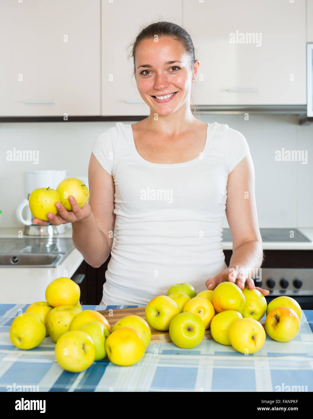 Young spanish woman cooking dish from apples in kitchen Stock Photo - Alamy
