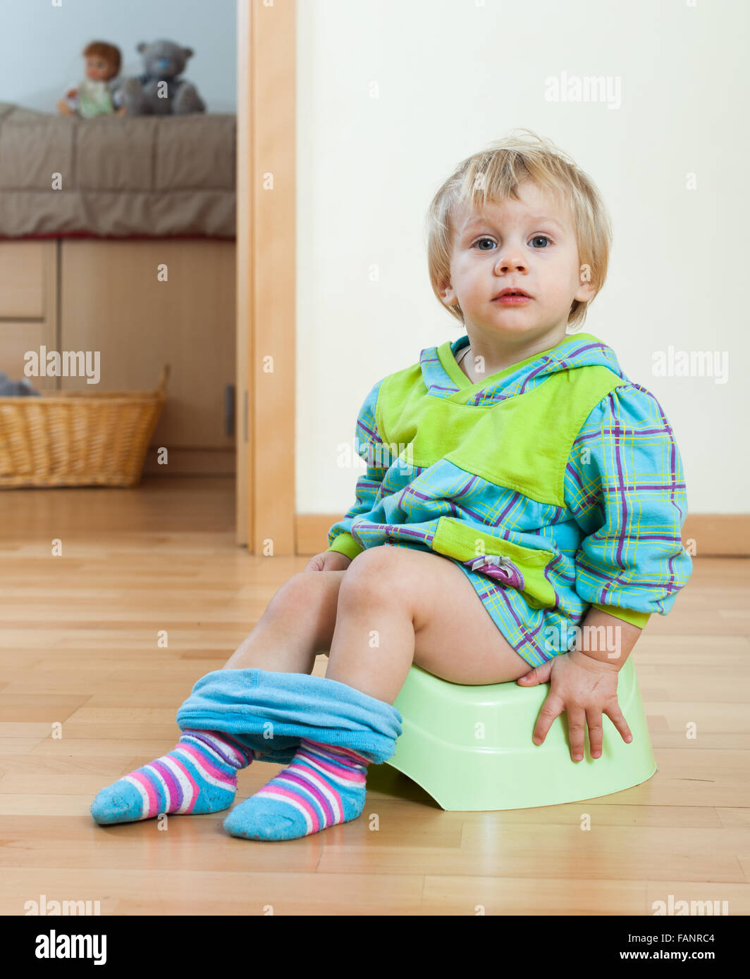 Baby sitting on potty in home interior Stock Photo - Alamy