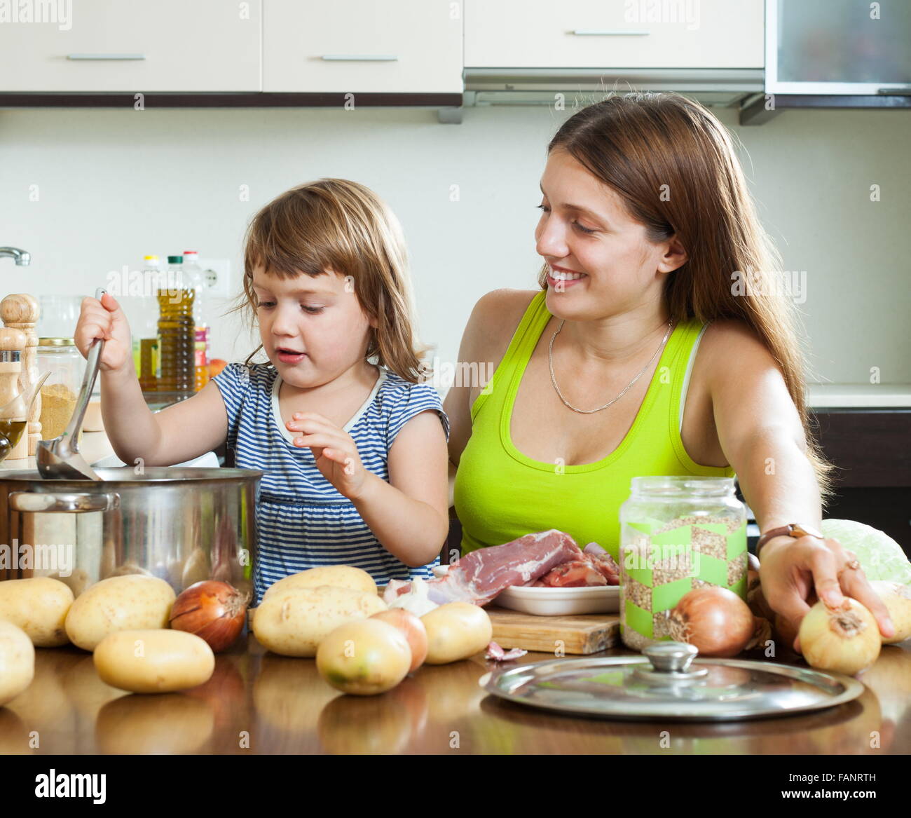 Happy mother with child cooking soup Stock Photo - Alamy