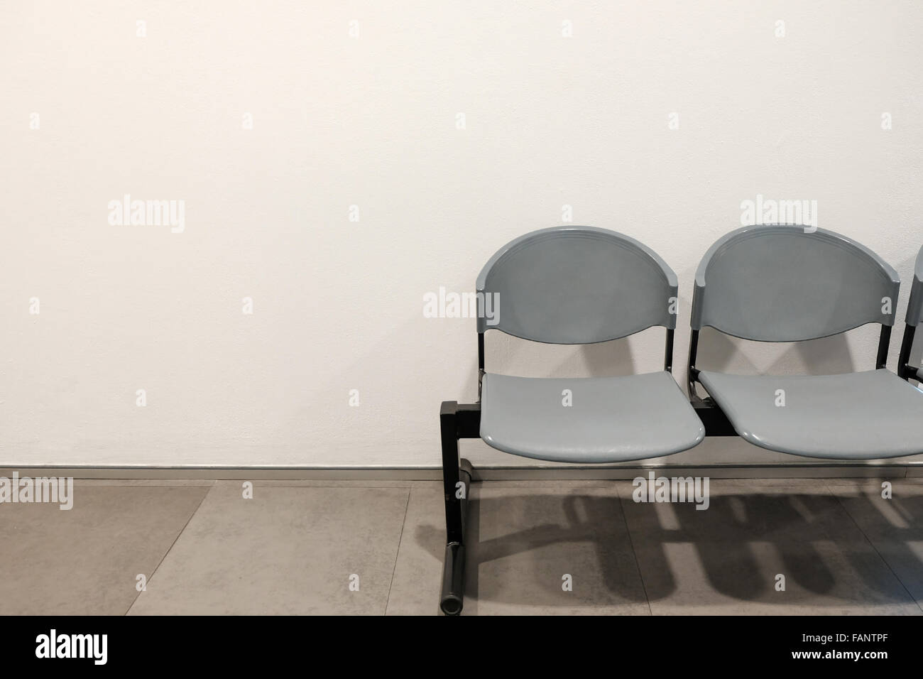 Two empty chairs by concrete wall with copyspace Stock Photo - Alamy