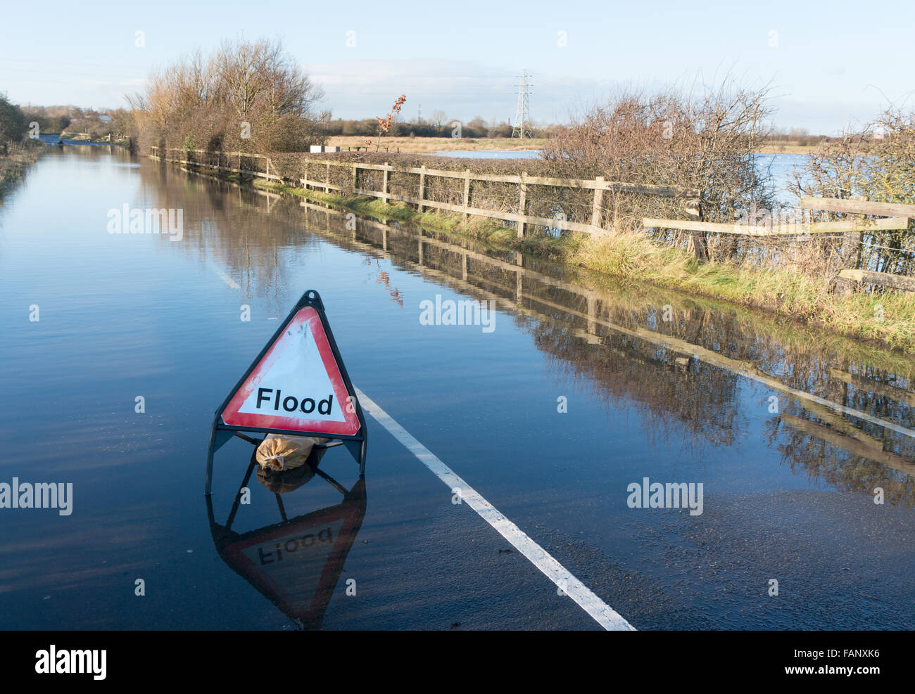 A closed flooded minor road with a triangular flood warning sign, north ...