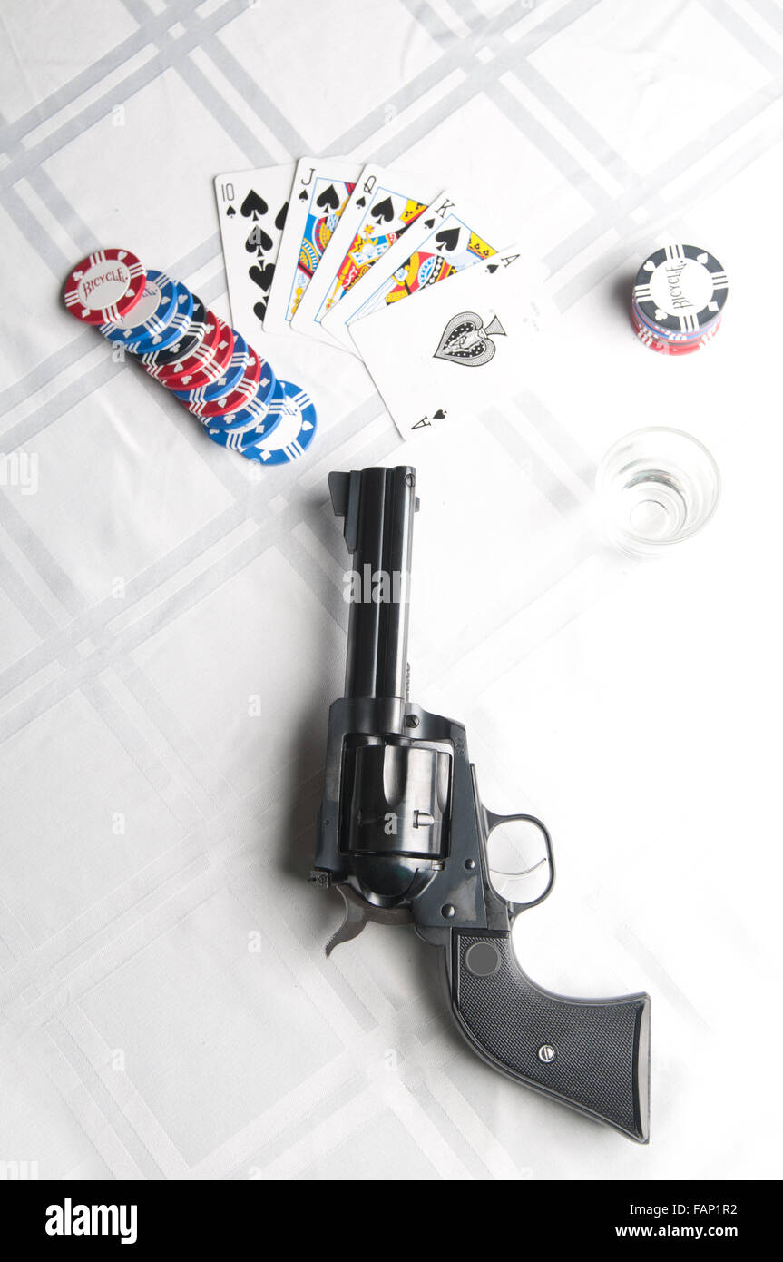 The old west poker game with six shooter, whiskey, cards and chips. A ...