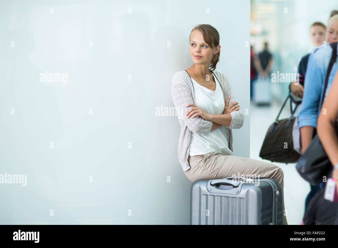 Young female passenger at the airport, about to check-in Stock Photo ...