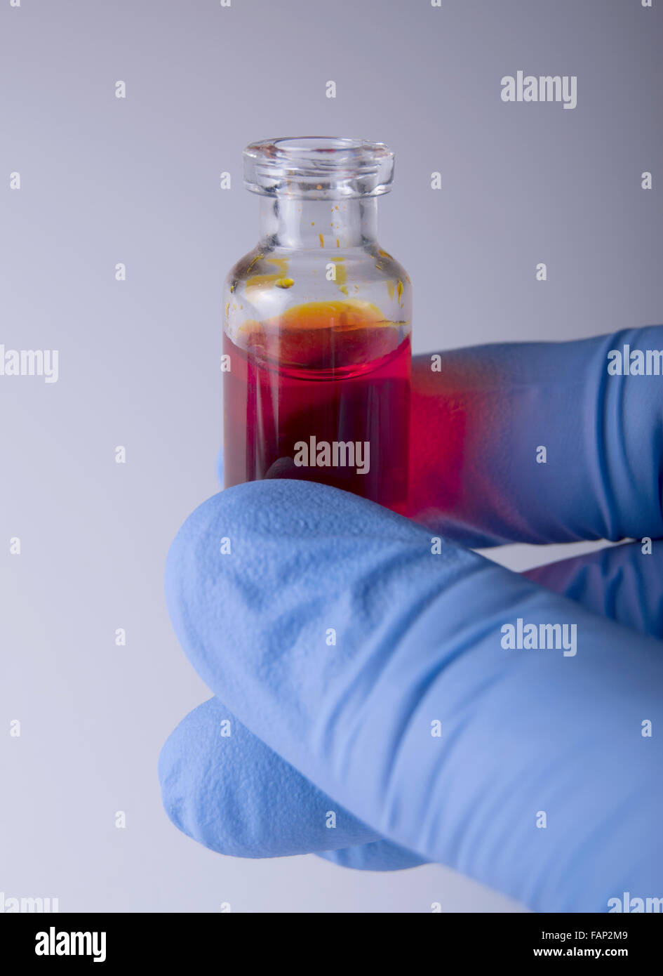 red medicine in vial held by gloved hand Stock Photo - Alamy