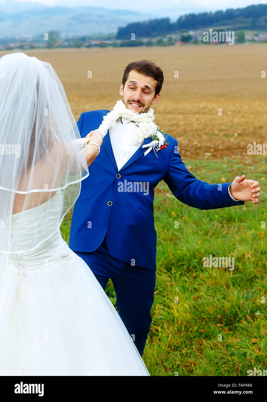 bride pulling her groom to her with a rope - funny wedding concept ...