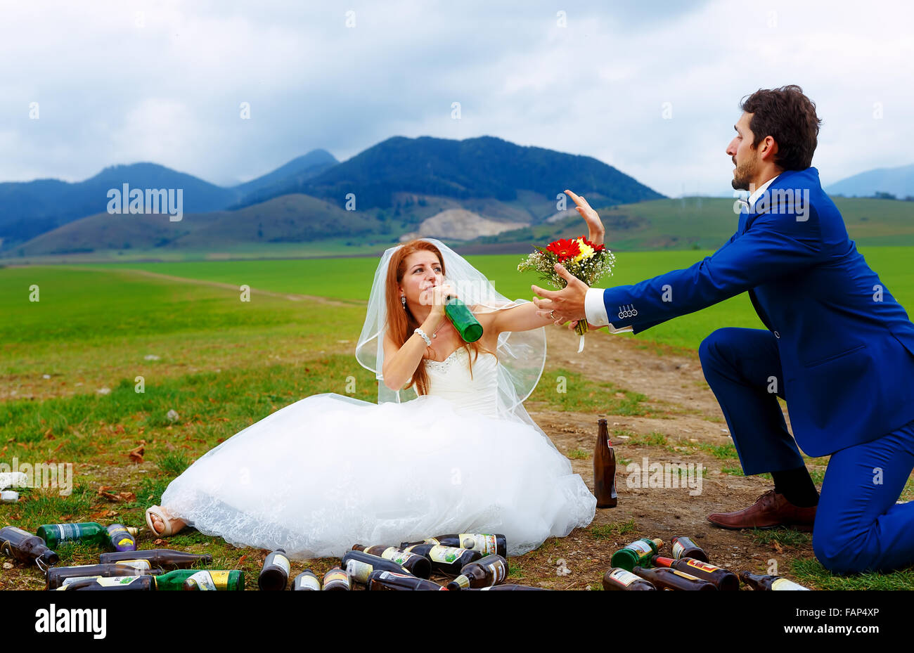drunken bride with lots of empty beer bottles in mountain landscape and ...
