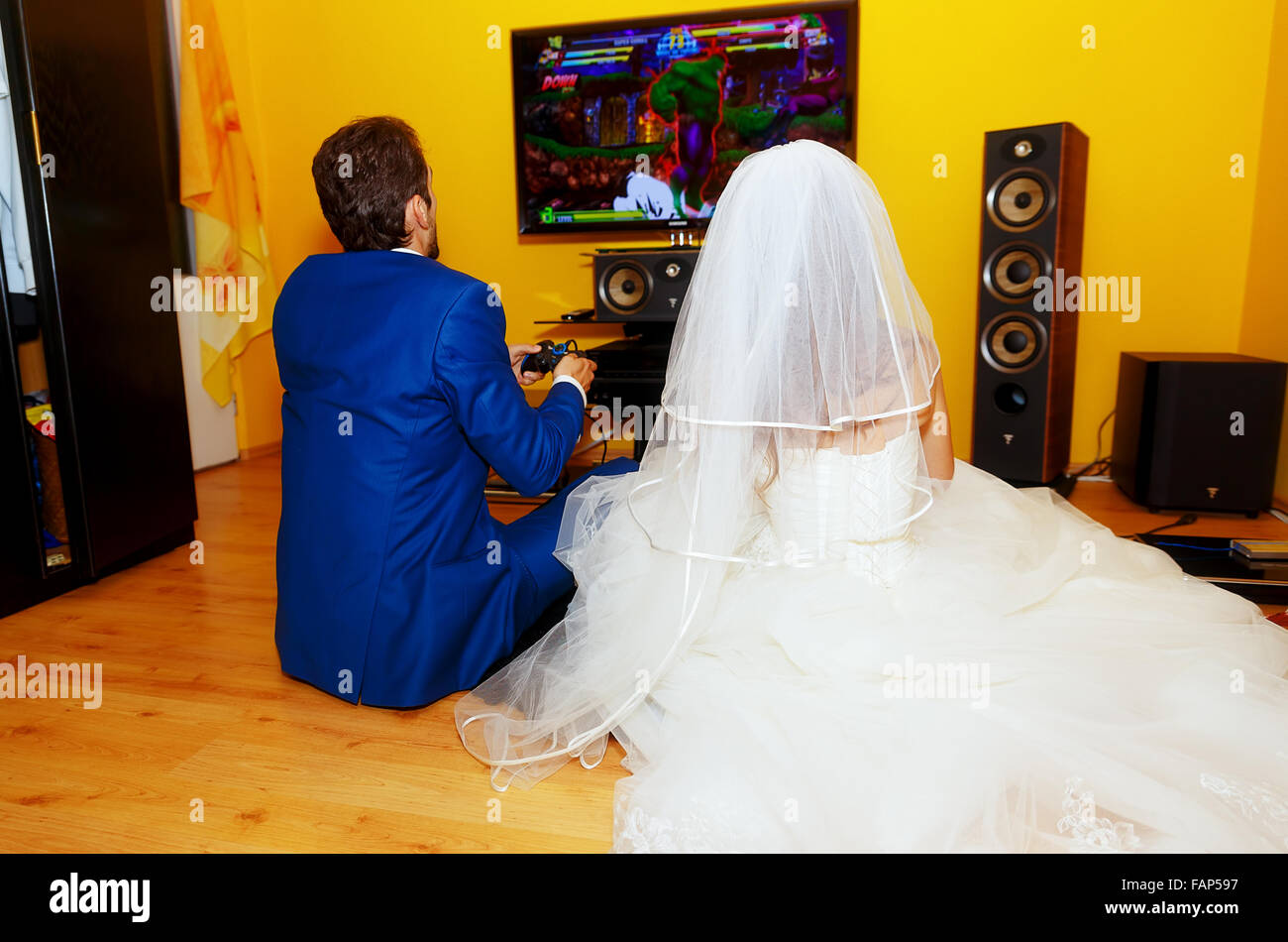 bride and groom playing together videogames with joysticks - gaming and ...