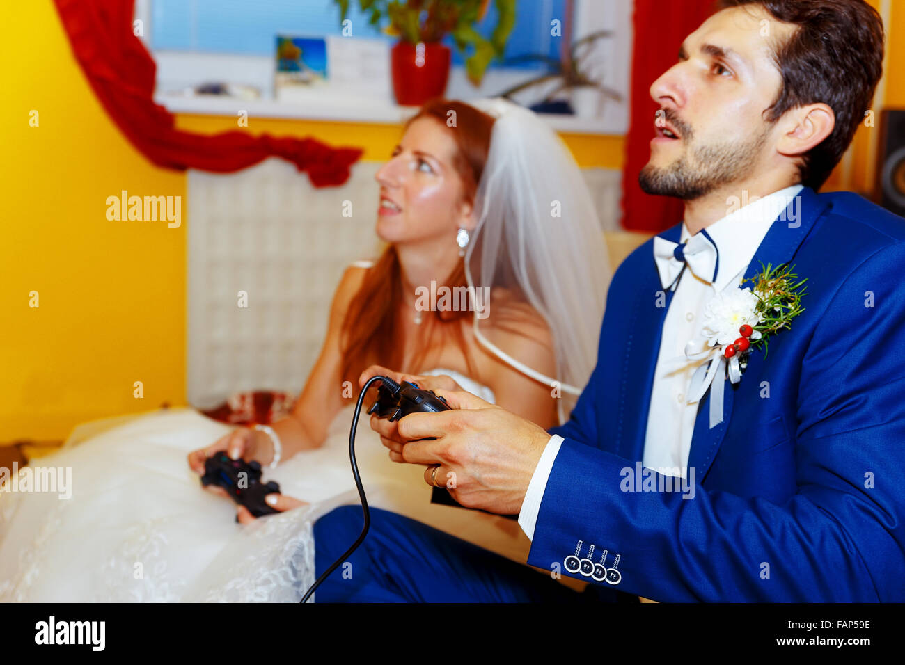 bride and groom playing together videogames with joysticks - gaming and ...