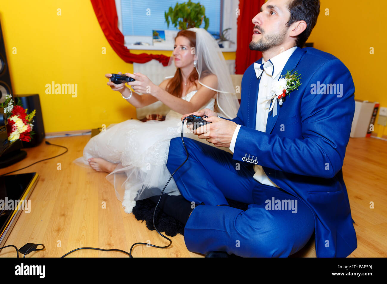 bride and groom playing together videogames with joysticks - gaming and ...