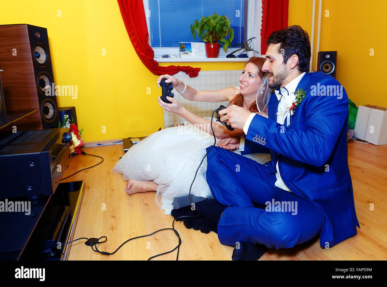 bride and groom playing together videogames with joysticks - gaming and ...
