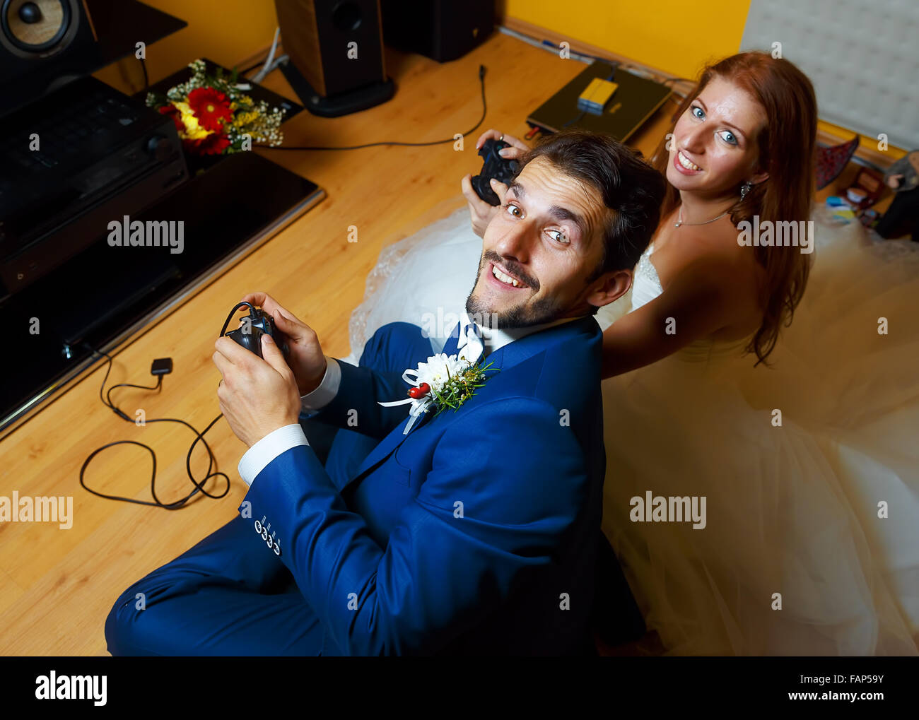 bride and groom playing together videogames with joysticks - gaming and ...