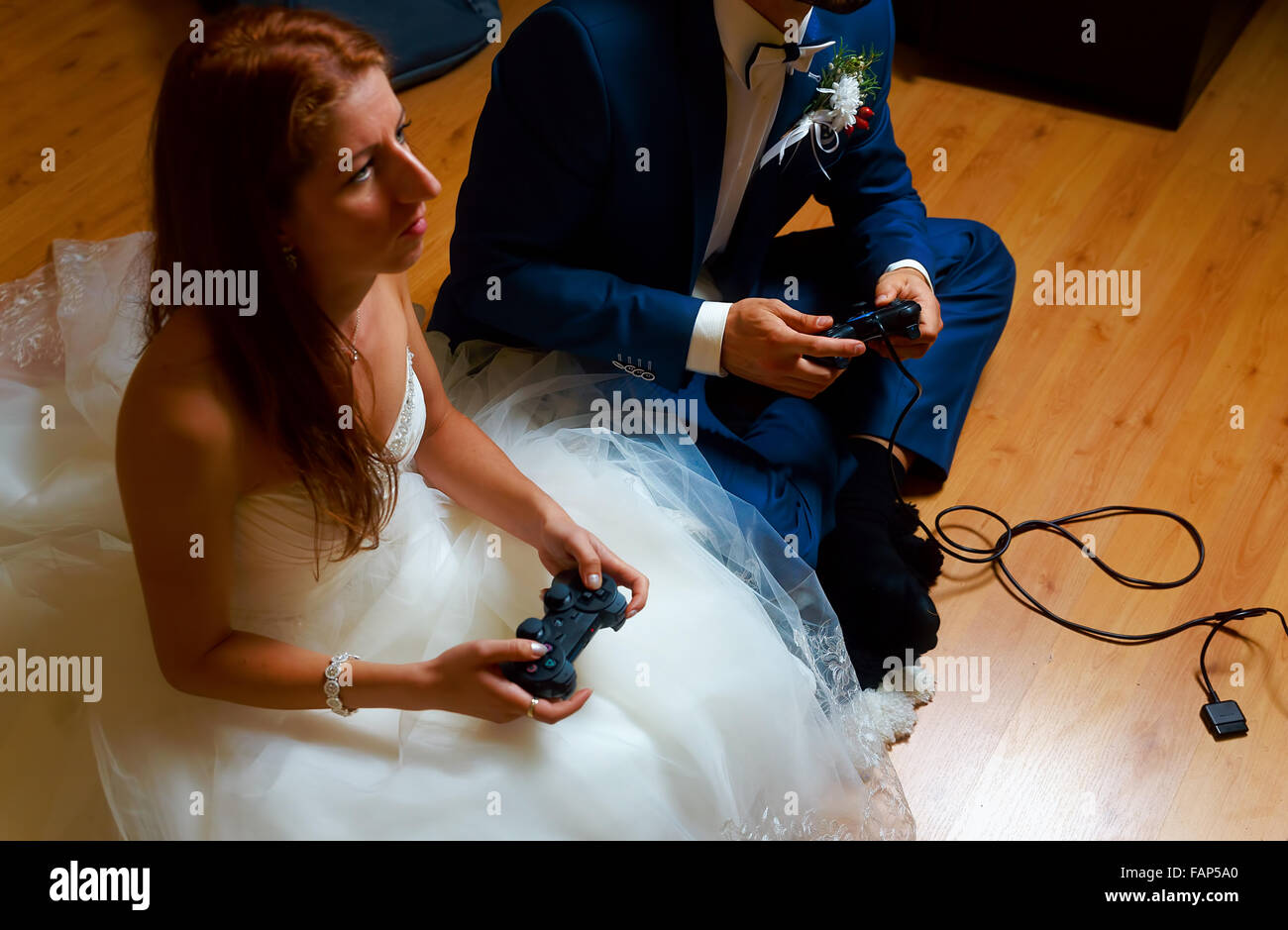 bride and groom playing together videogames with joysticks - gaming and ...