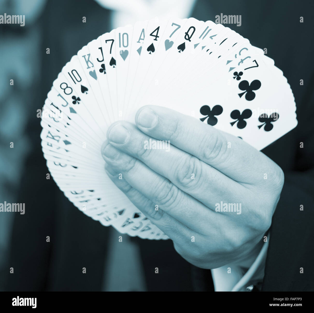 Playing cards spread out in hand of magician photo Stock Photo - Alamy