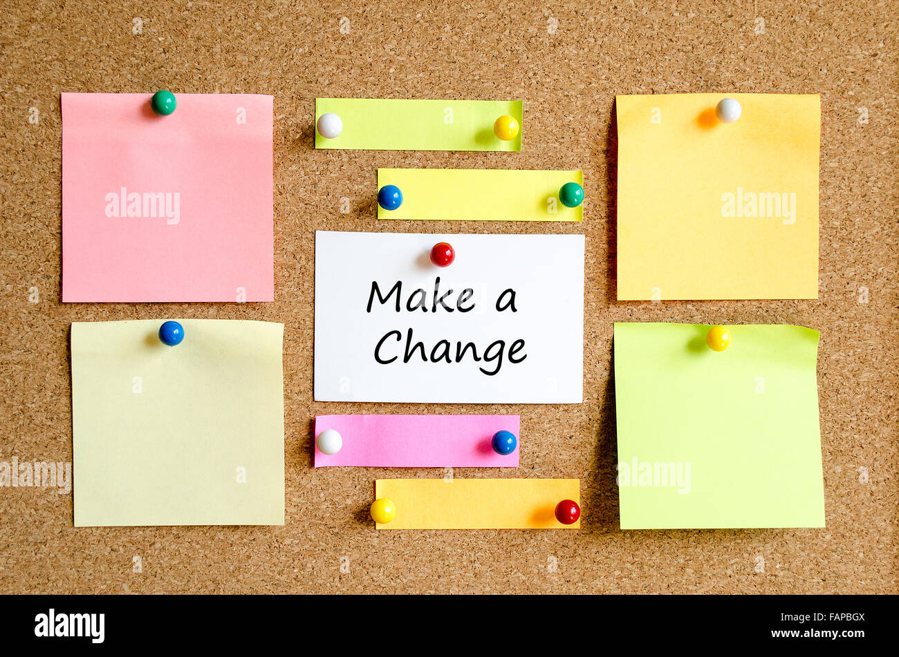 Colorful sticky notes on cork board background and text concept make a ...