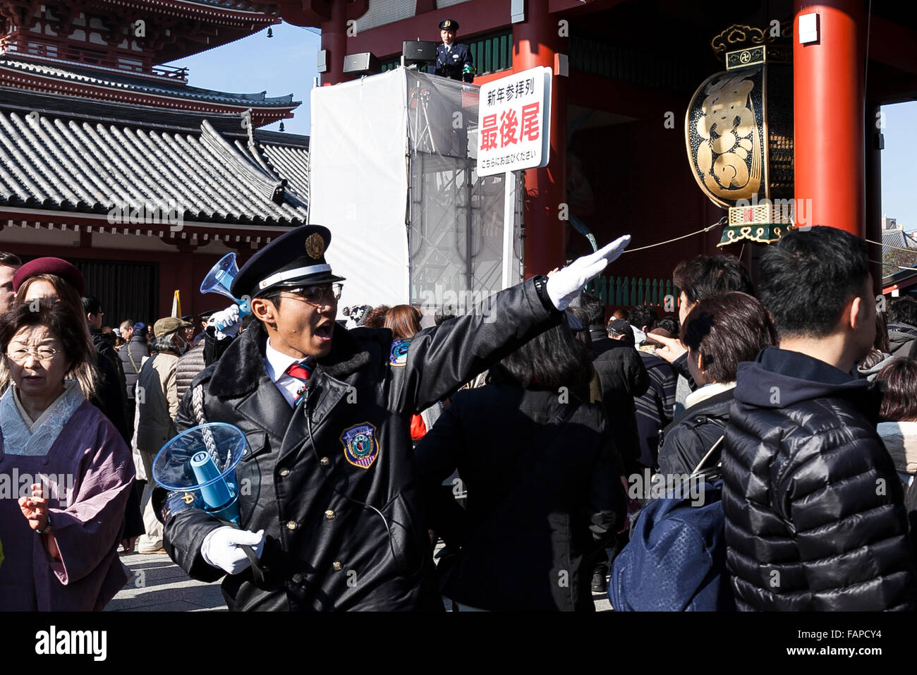 Tokyo, Japan. 3rd Jan, 2016. A security guard guides people during the ...