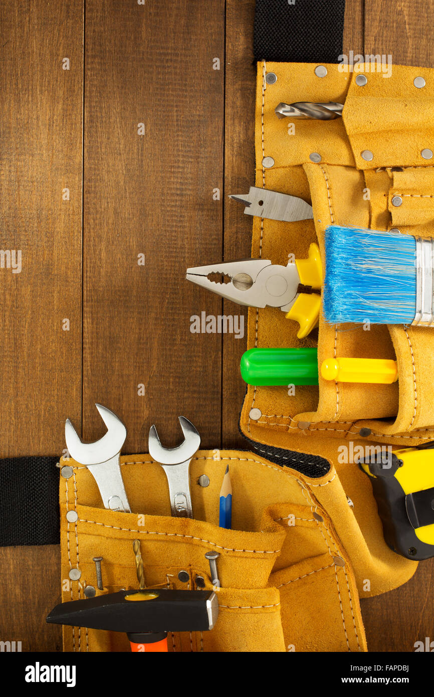 tools and instruments in belt on wooden background Stock Photo - Alamy