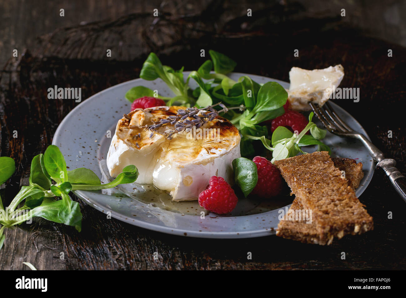 Baked Goat cheese with honey and raspberries Stock Photo - Alamy