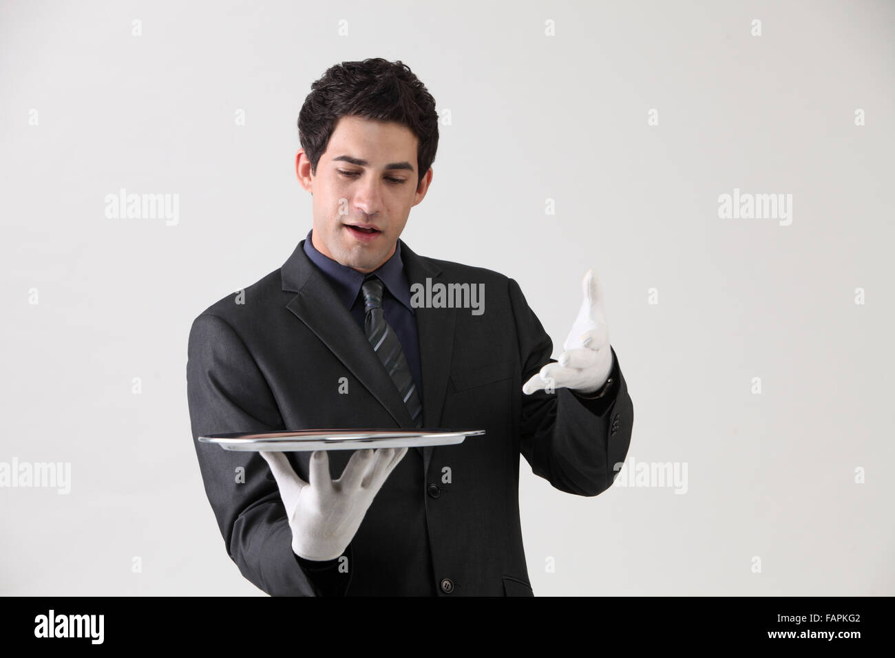 Butler holding an empty silver tray Stock Photo - Alamy