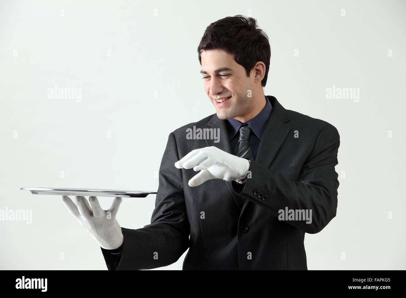 Butler holding an empty silver tray Stock Photo - Alamy