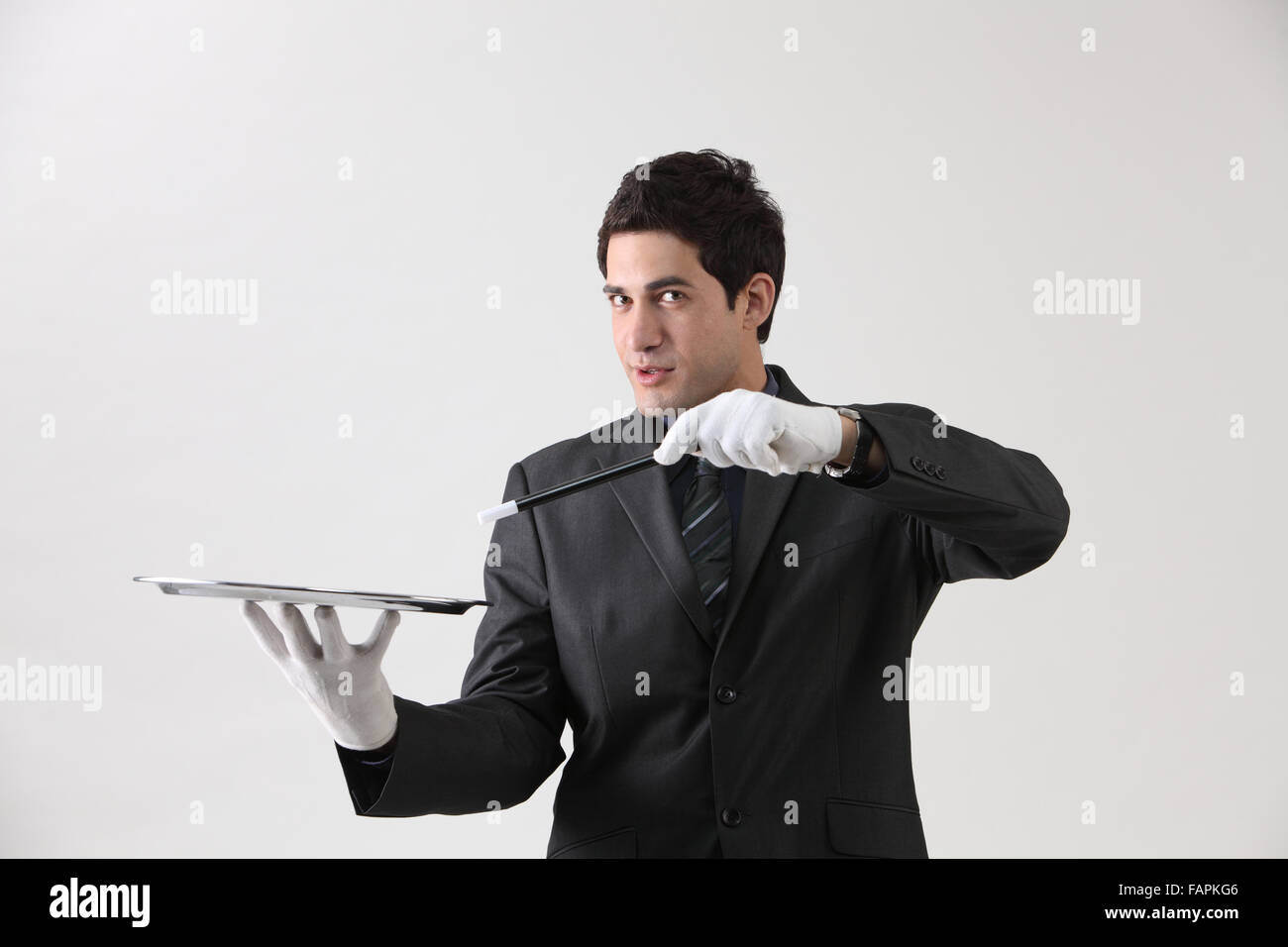businessman holding a magic wand and a tray Stock Photo - Alamy
