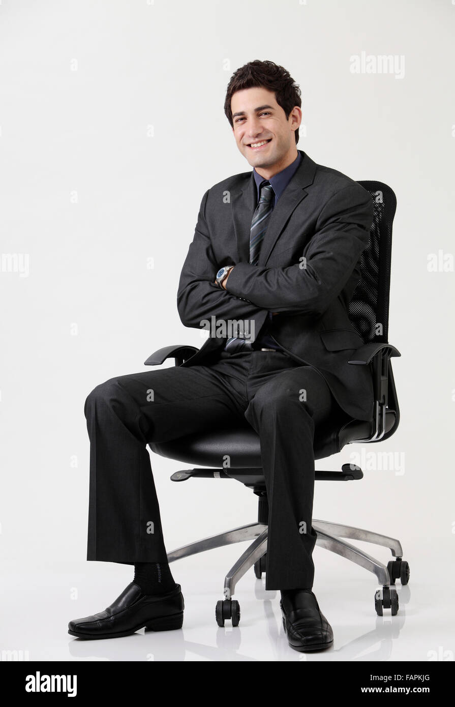 Business man sitting on office chair crossing arm Stock Photo - Alamy