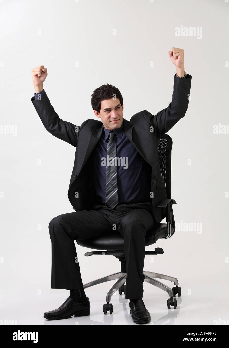 Business man sitting on office chair with arm raised Stock Photo - Alamy