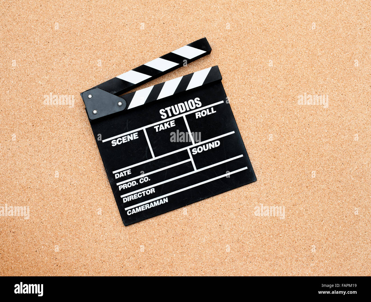 Black vintage movie clapper board centered on cork wooden background ...