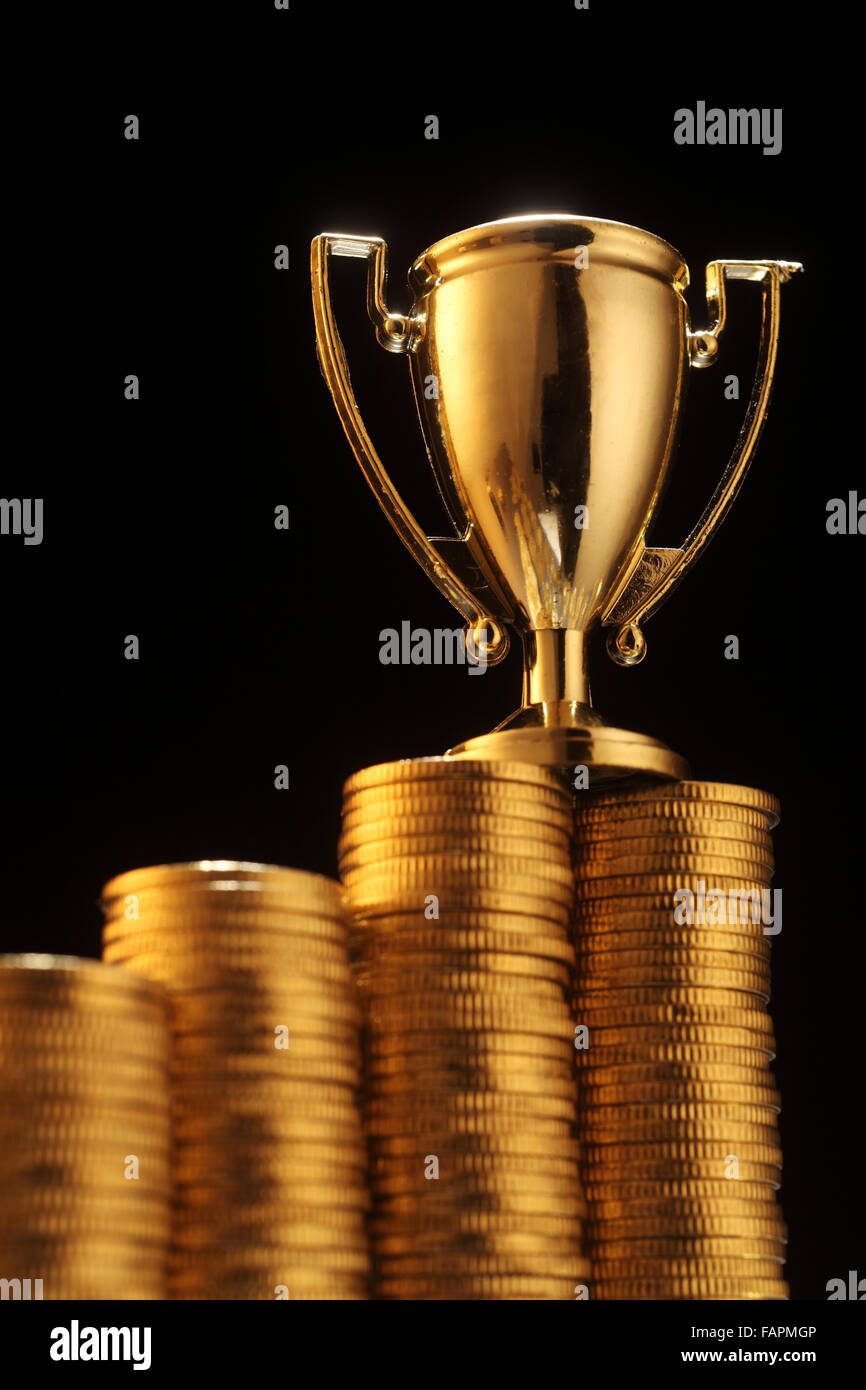trophy on stack of coins Stock Photo - Alamy