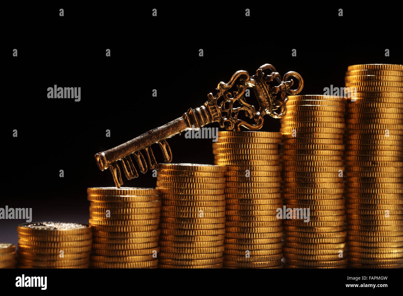 key resting on the stack of coin Stock Photo - Alamy