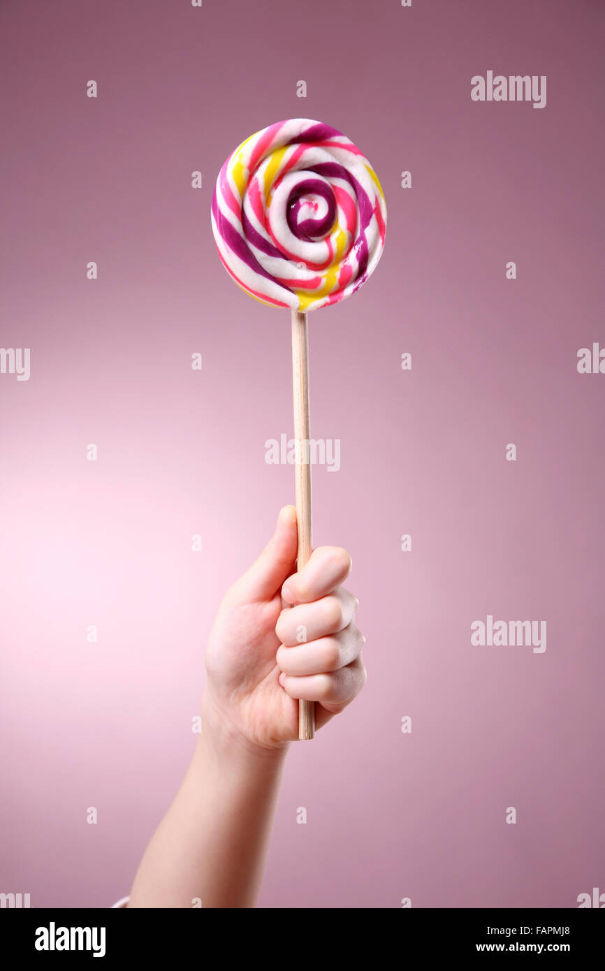 close up of kid's hand holding lollipop Stock Photo - Alamy