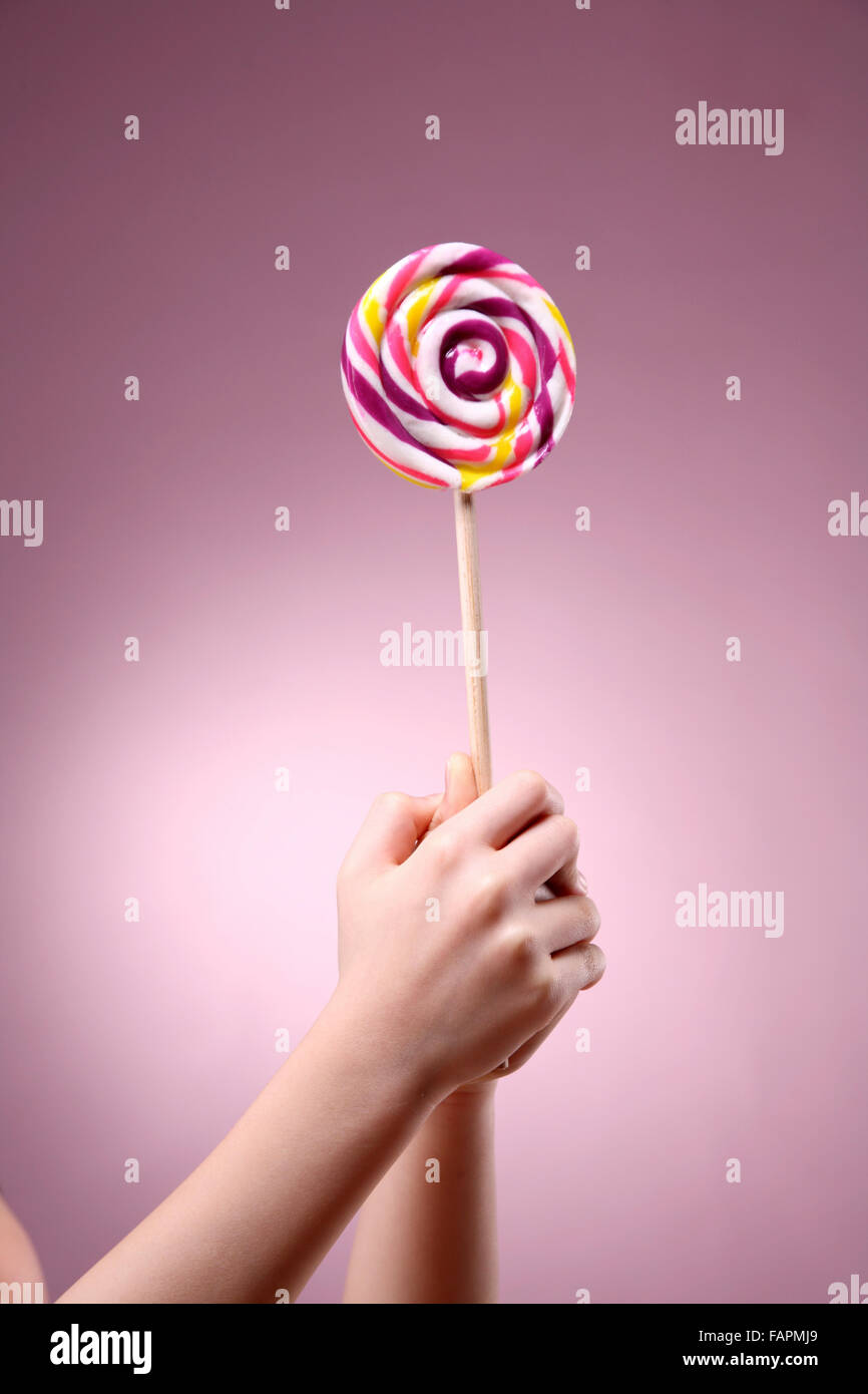 close up of kid's hand holding lollipop Stock Photo - Alamy