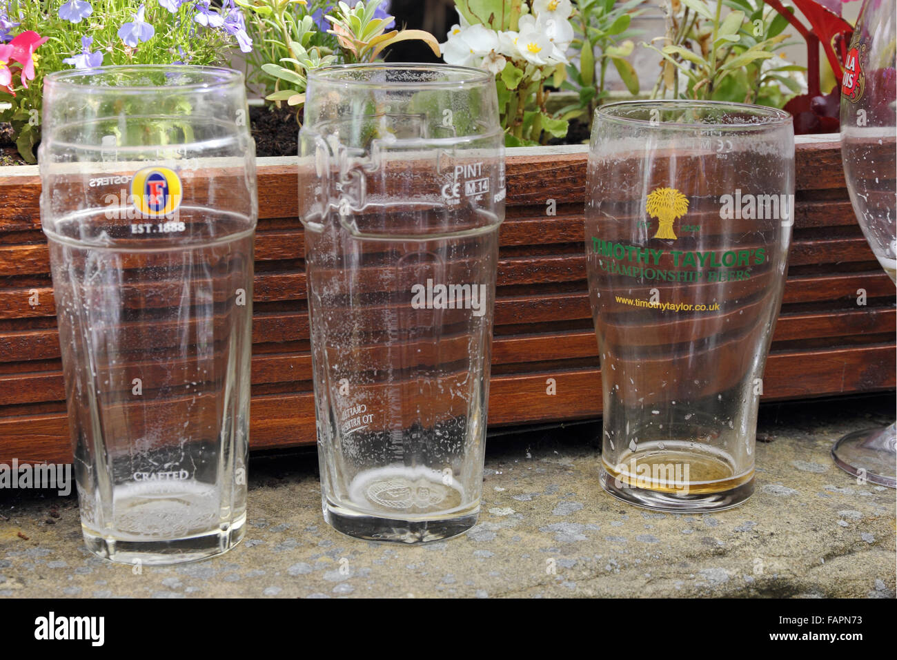 Empty pint beer glasses on top of wall outside public house Stock Photo ...