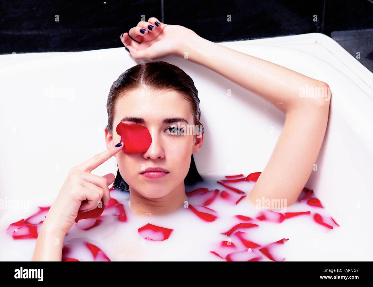 Girl in bath with rose petals Stock Photo - Alamy