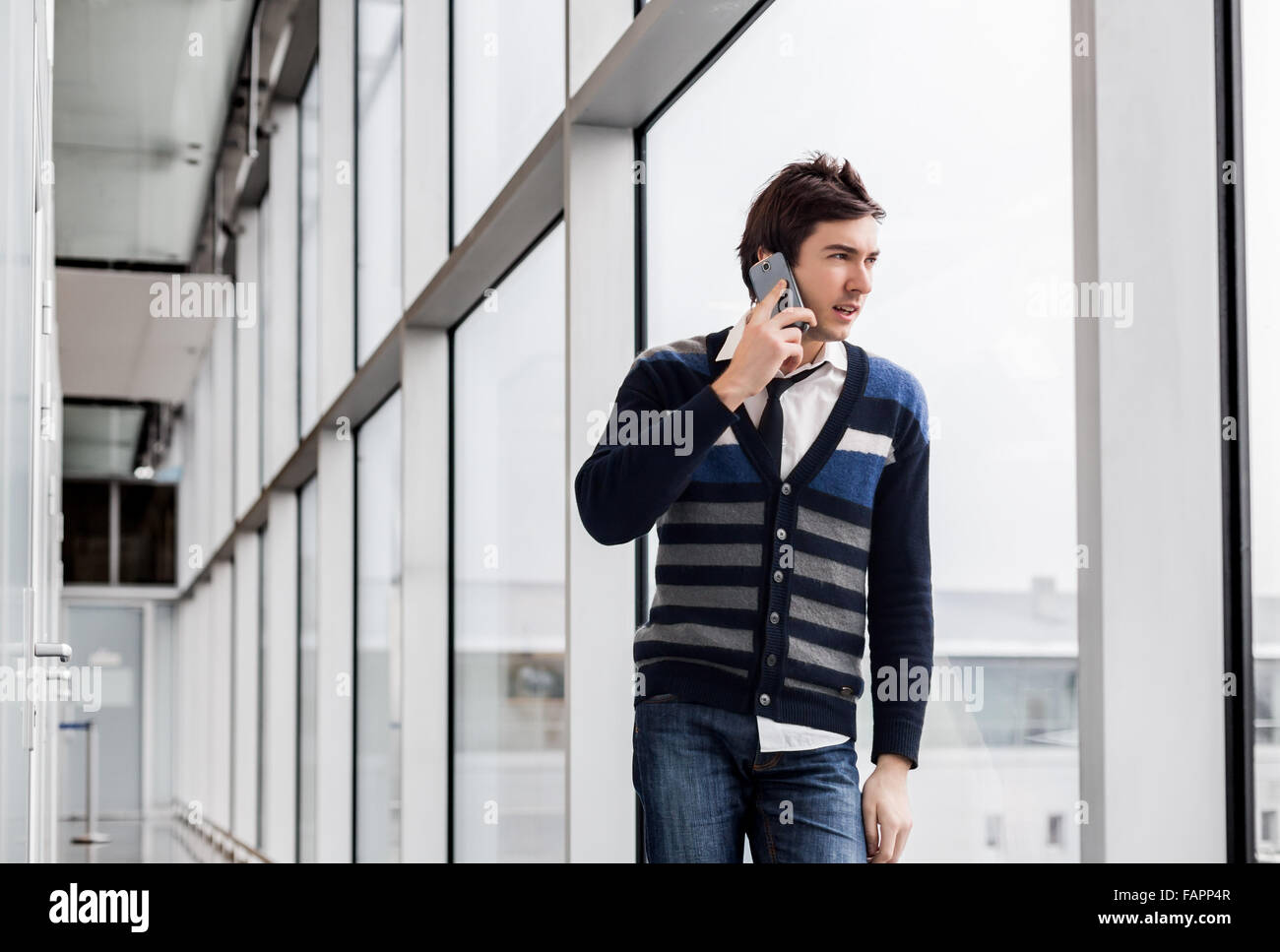 Urban business man talking phone near a window Stock Photo - Alamy