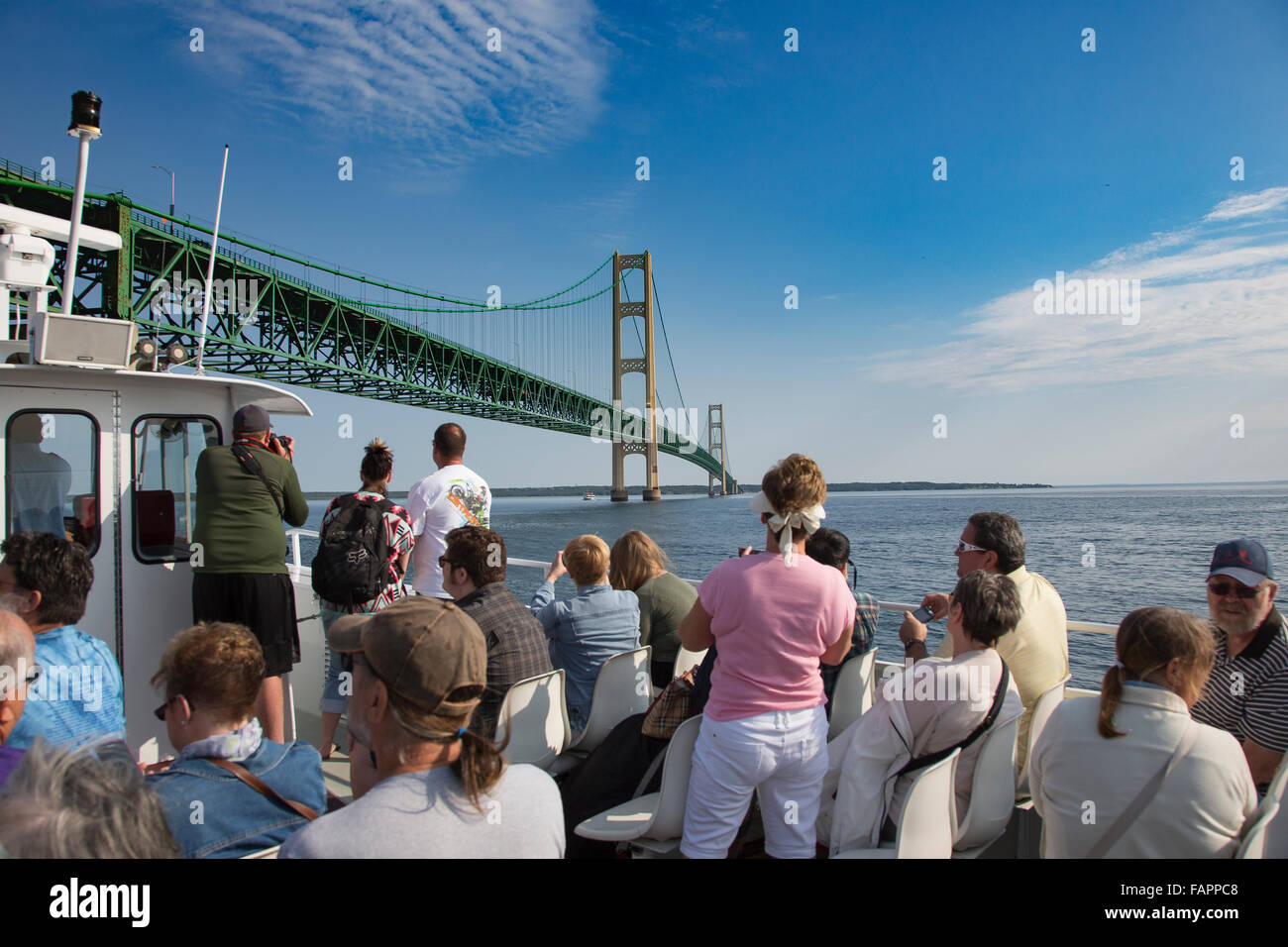 Touriist on ferry under The Mackinac Suspension Bridge opened in 1957 ...