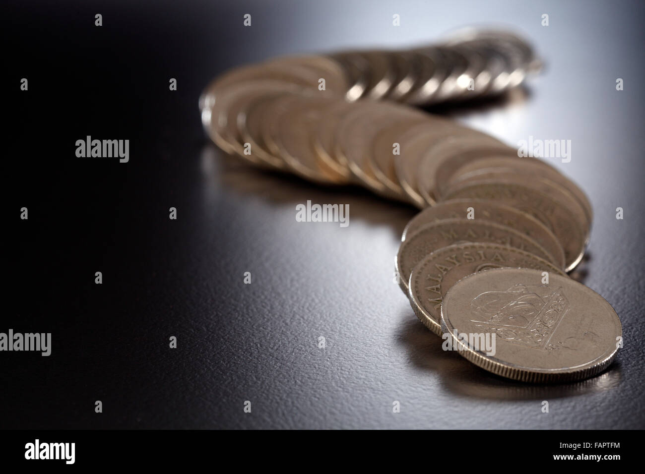 Row of coins on the black background Stock Photo - Alamy