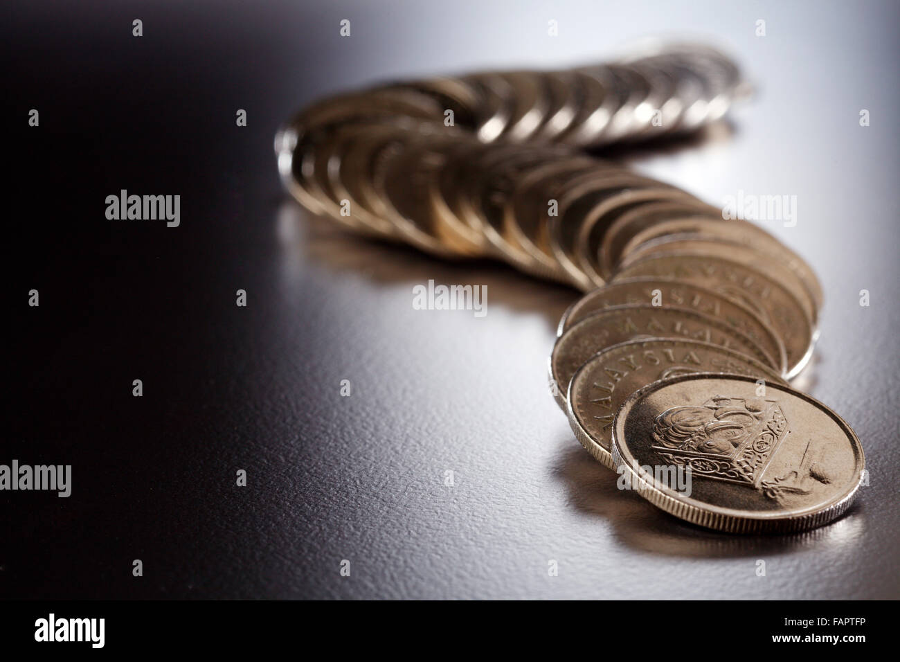 Row of coins on the black background Stock Photo - Alamy