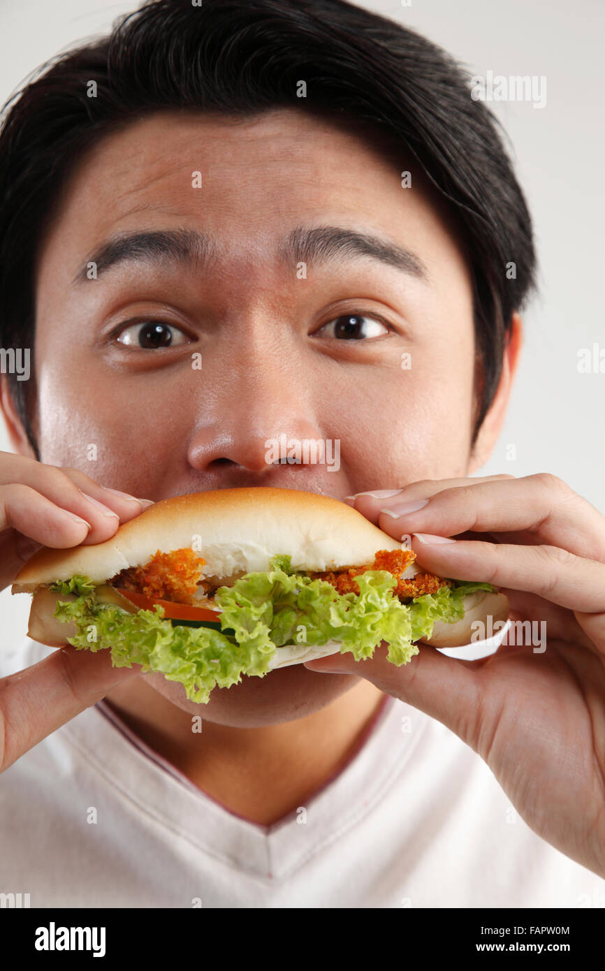 man eating burger on the white background Stock Photo - Alamy