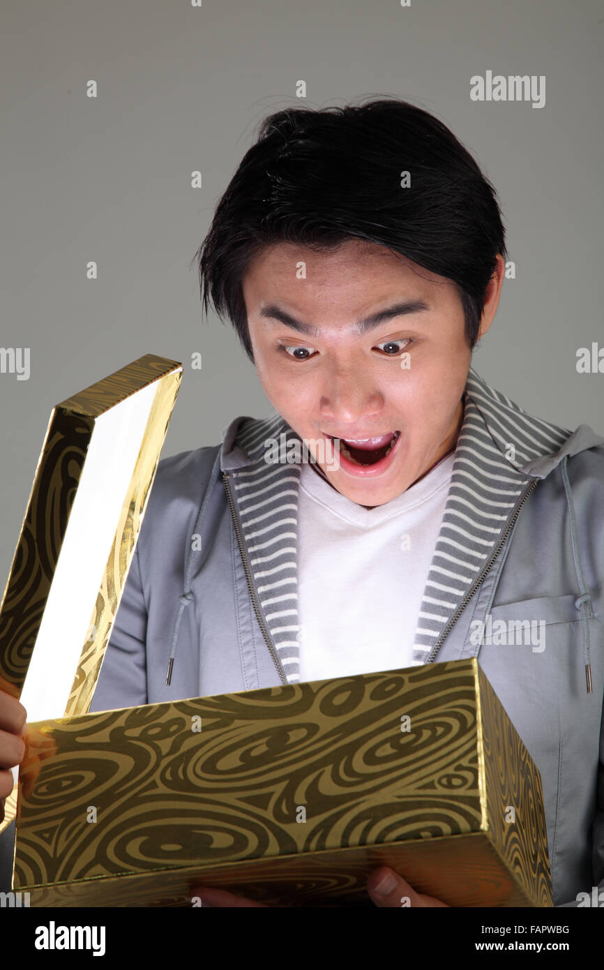 Surprised man opening a glowing box Stock Photo - Alamy