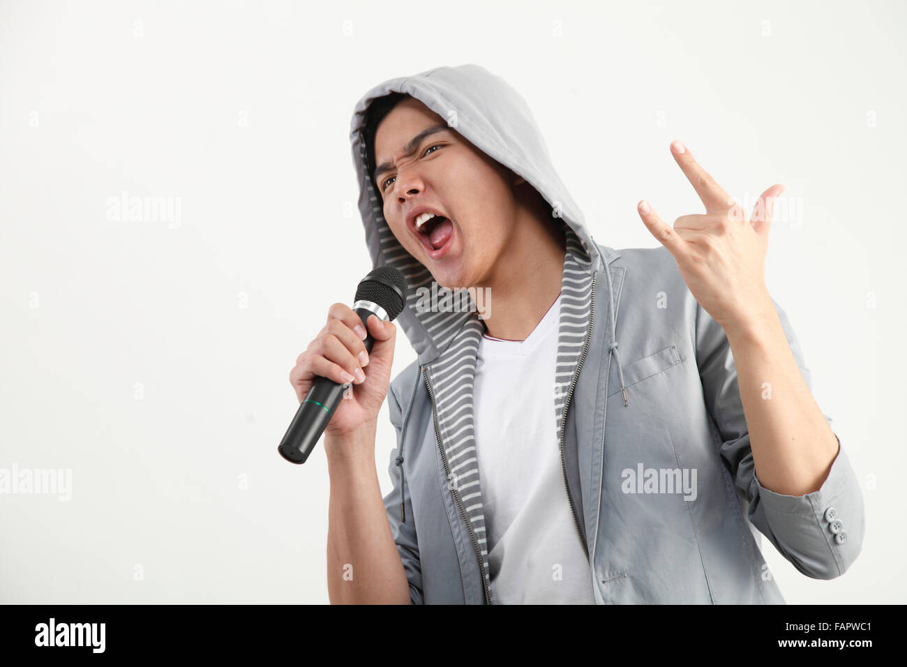 man holding microphone with the hand sign Stock Photo - Alamy