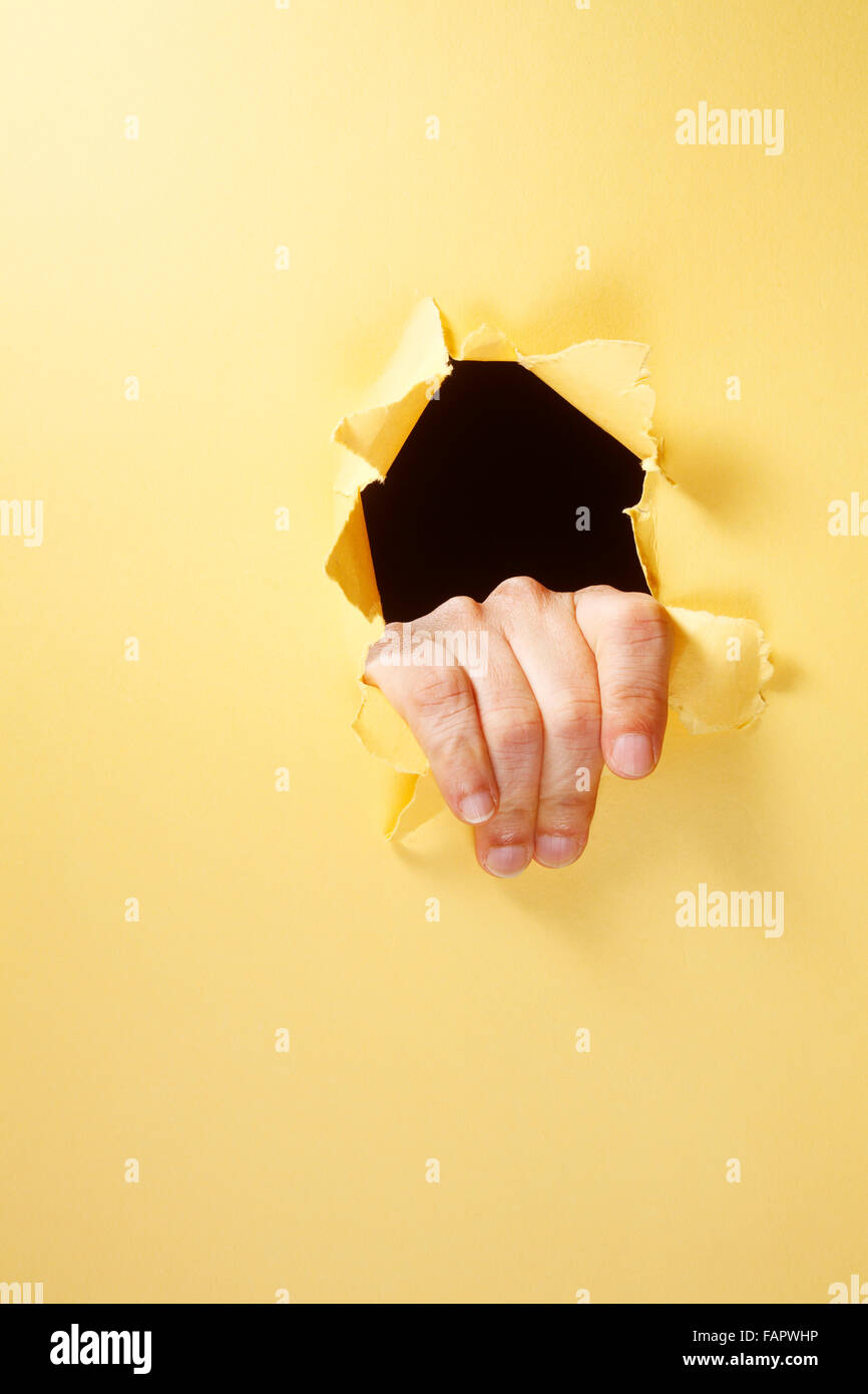 stock image of the hand breaking through a hole Stock Photo - Alamy