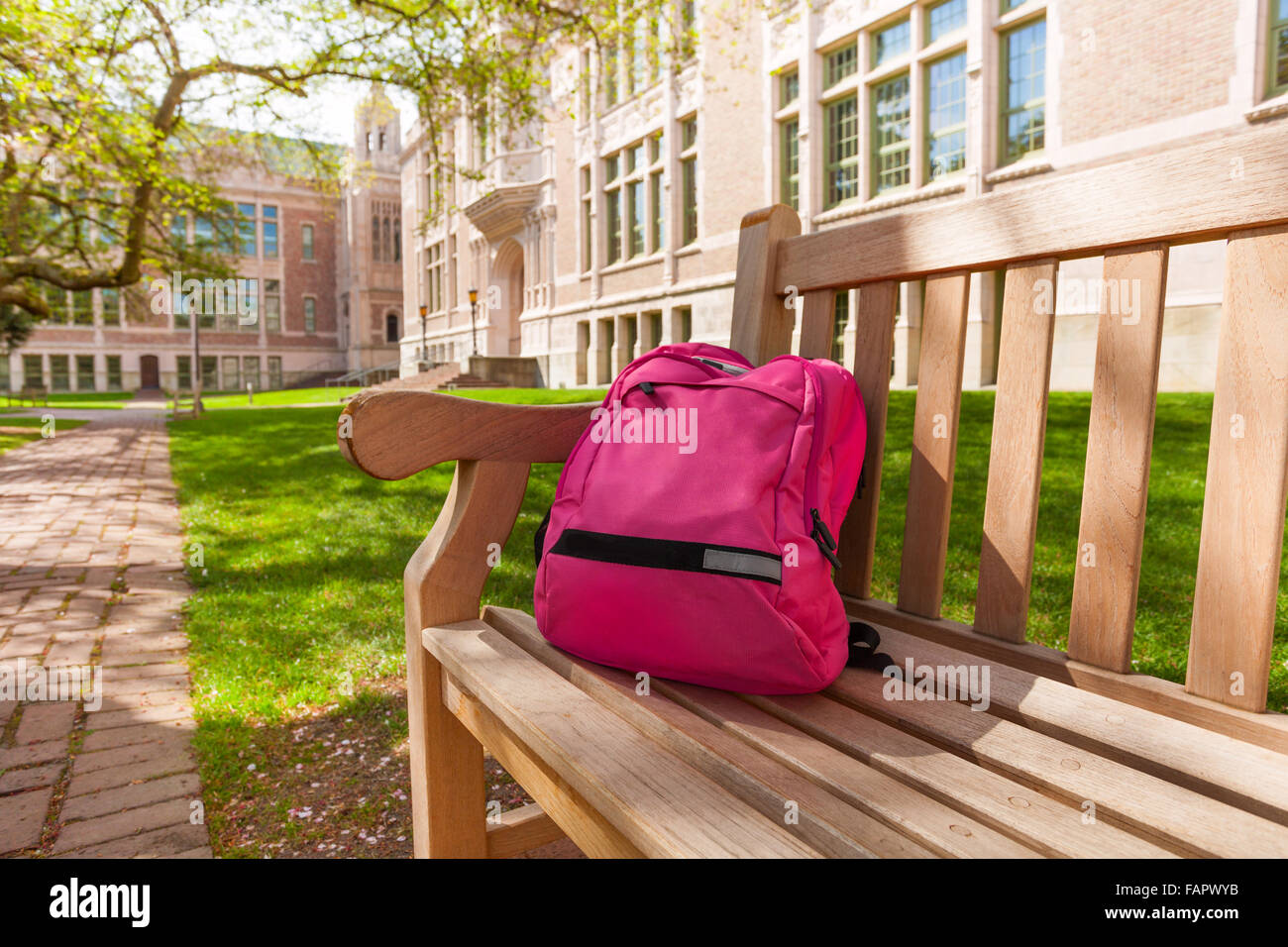 Backpack laying on university bench Stock Photo - Alamy