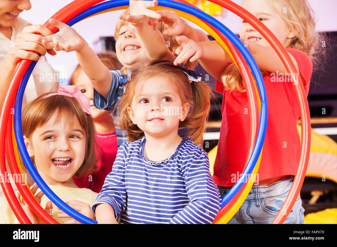 Boys and girls look though hoops Stock Photo - Alamy