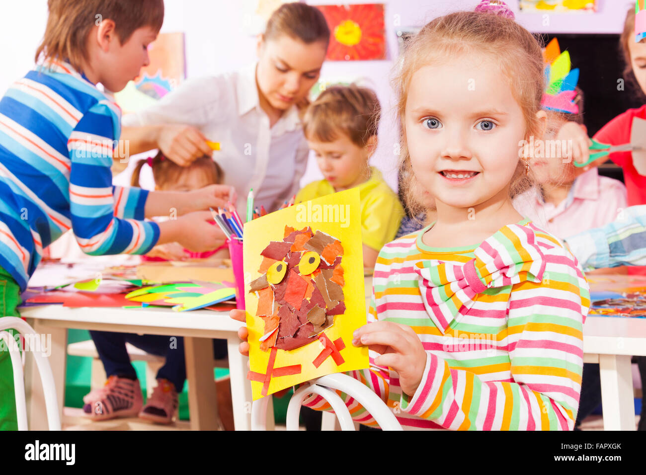 Girl hold picture and kindergarten class on back Stock Photo - Alamy