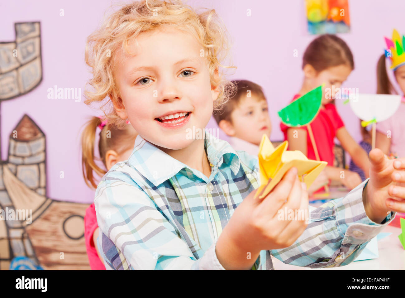 Blond handsome boy shows origami craft in class Stock Photo - Alamy