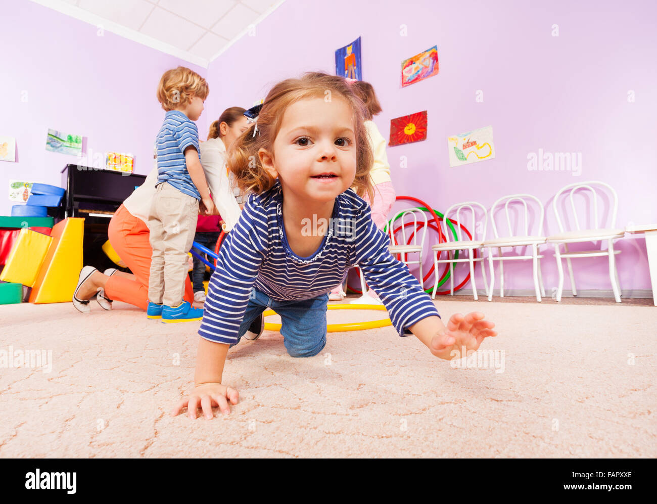 Girl crawl on active class lesson in kindergarten Stock Photo - Alamy